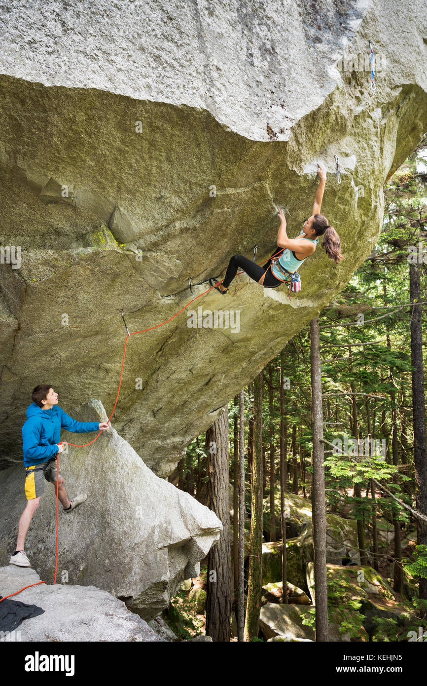 Boy watching girl rock climbing Stock Photo - Alamy
