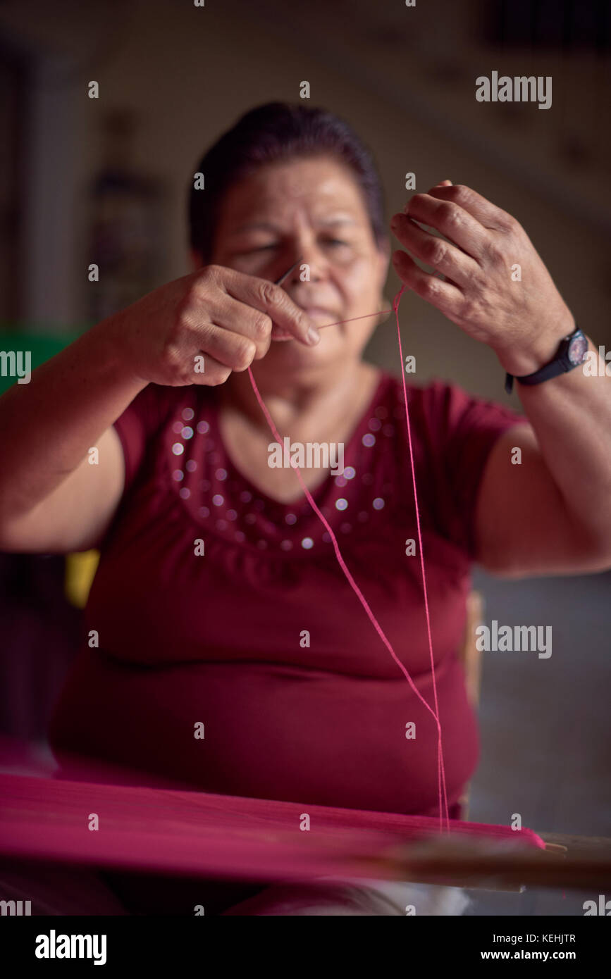 Hispanic woman weaving fabric on loom Stock Photo - Alamy