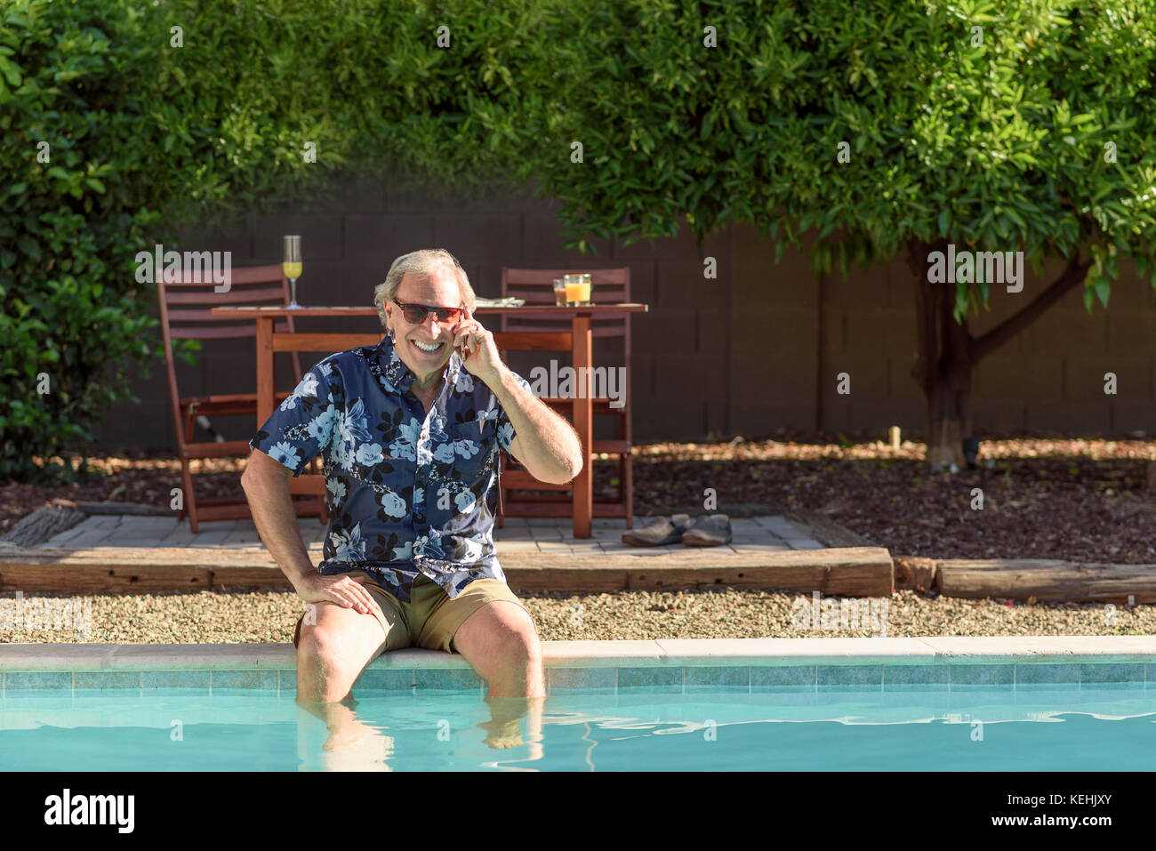 Man sitting by swimming pool hi-res stock photography and images - Alamy