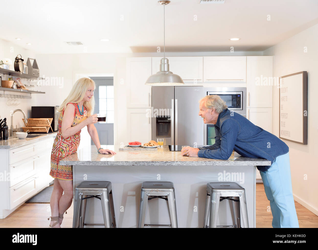 Woman standing at kitchen island hi-res stock photography and images ...