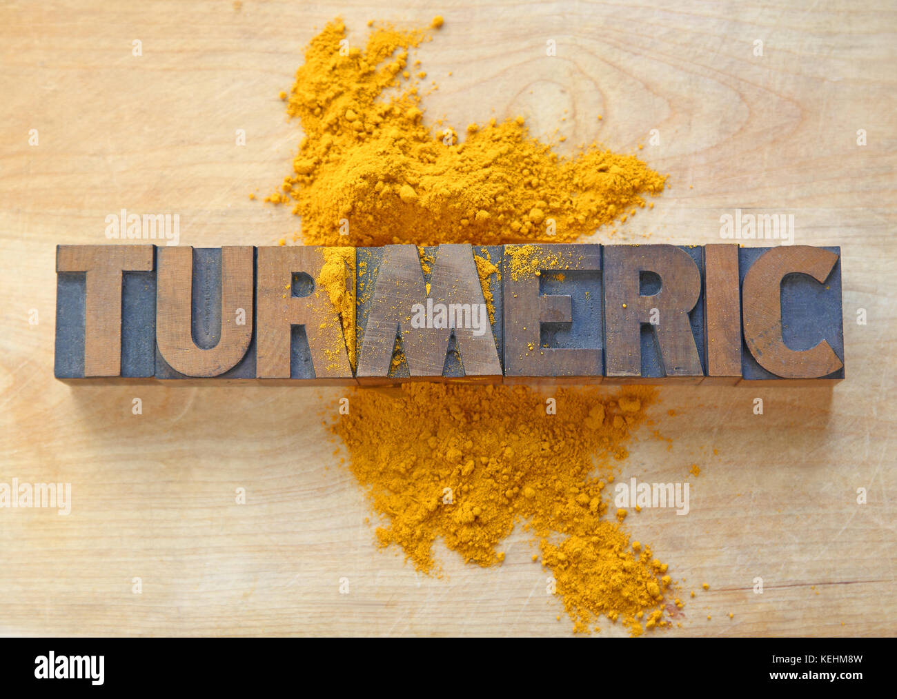 the word turmeric in antique old wood type on a cutting board with the ...