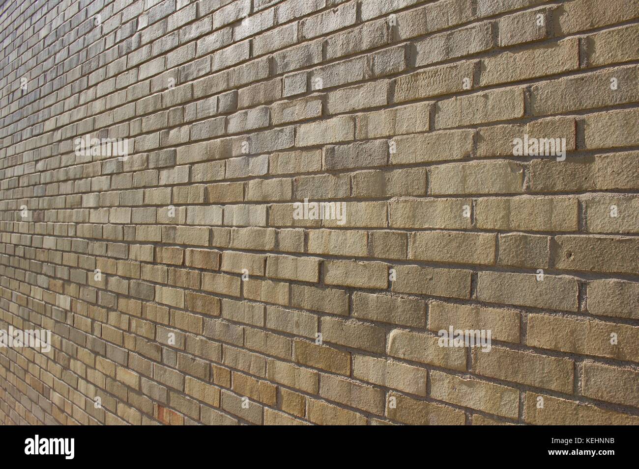 Close up angled view of a brightly sunlit beige and tan colored modern ...