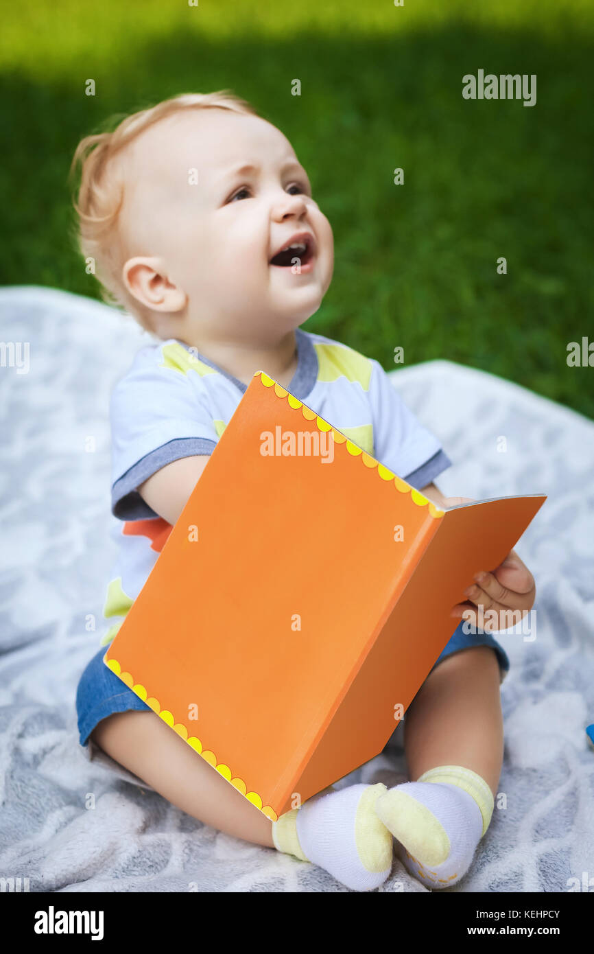 little baby reading book in park Stock Photo - Alamy