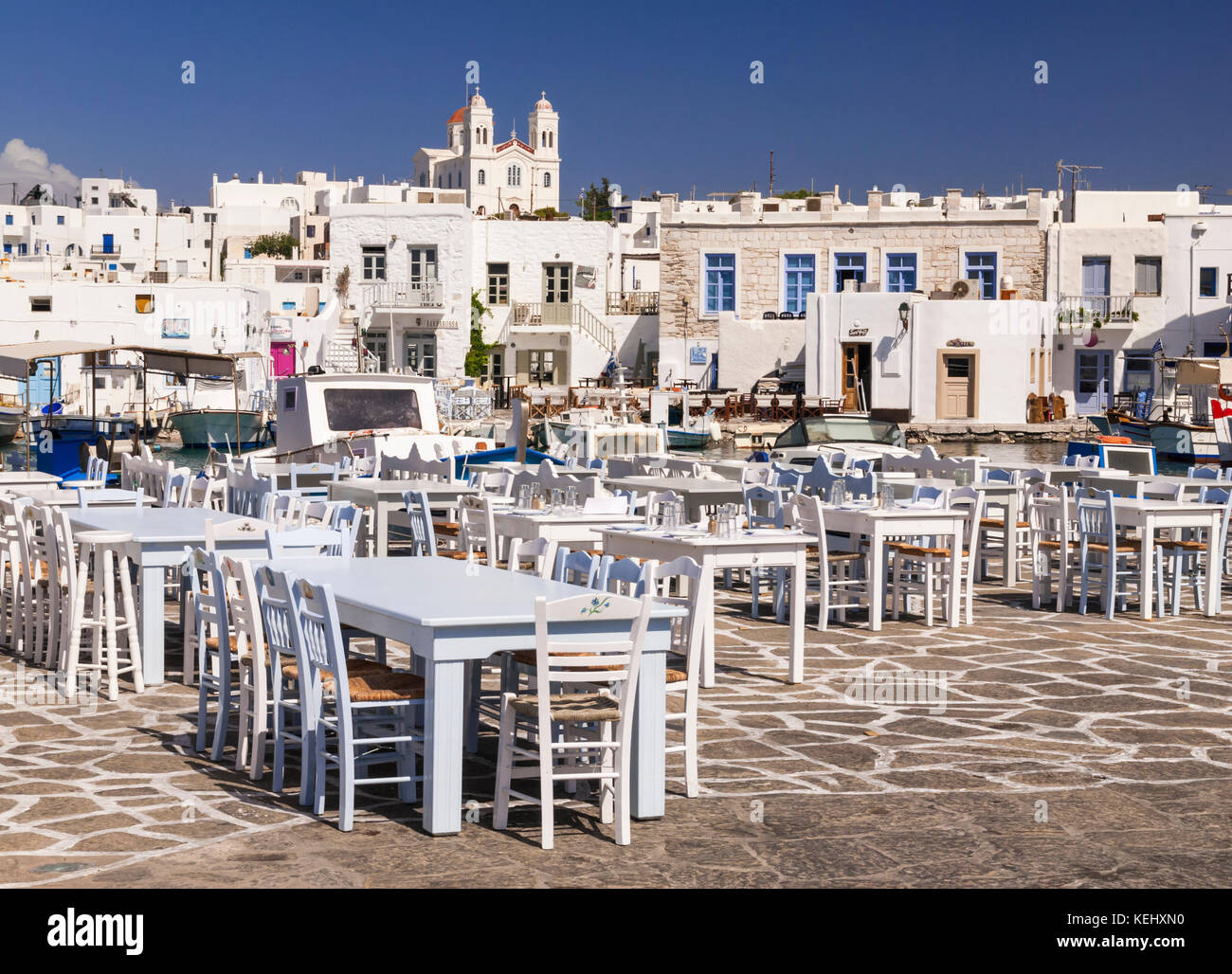Tables and chairs along the pretty waterfront of Naoussa Town, Paros ...