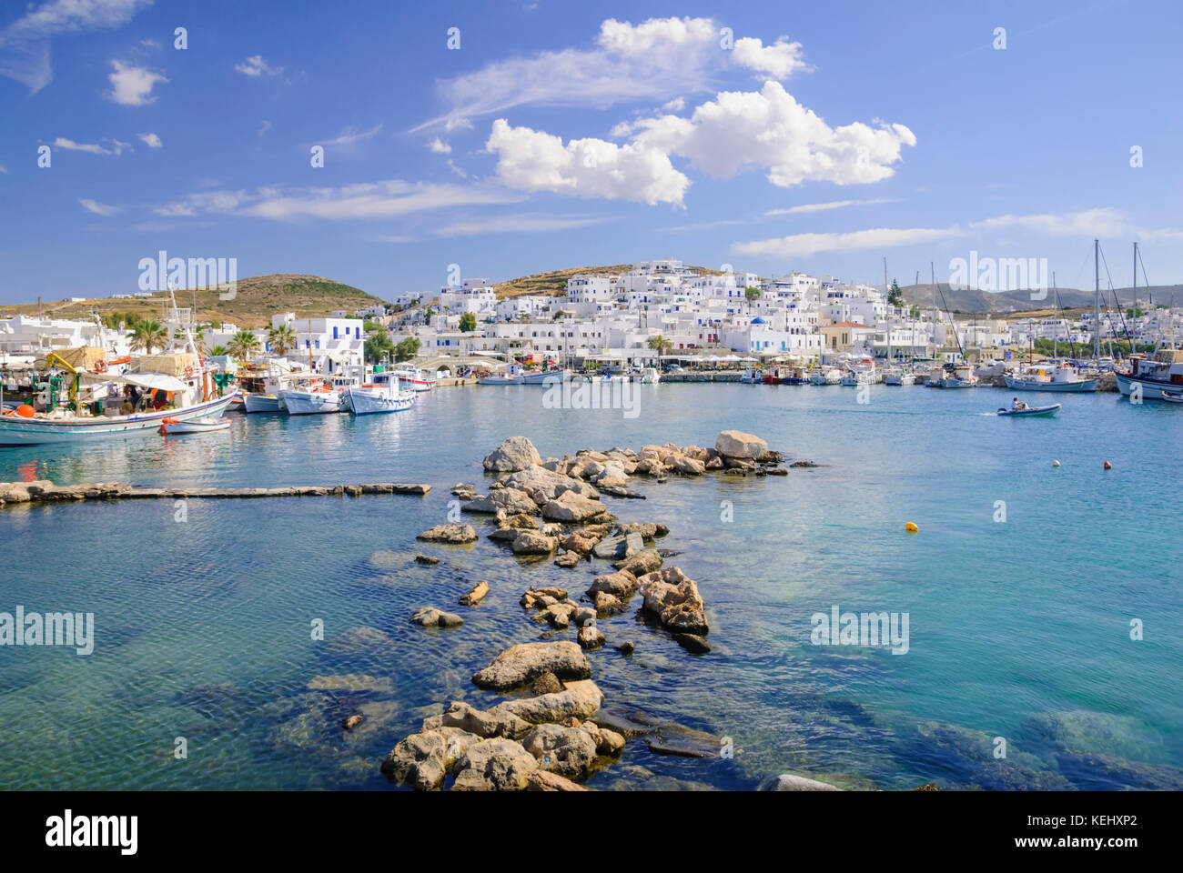 The whitewashed town of Naoussa overlooking the harbour and old ruins ...