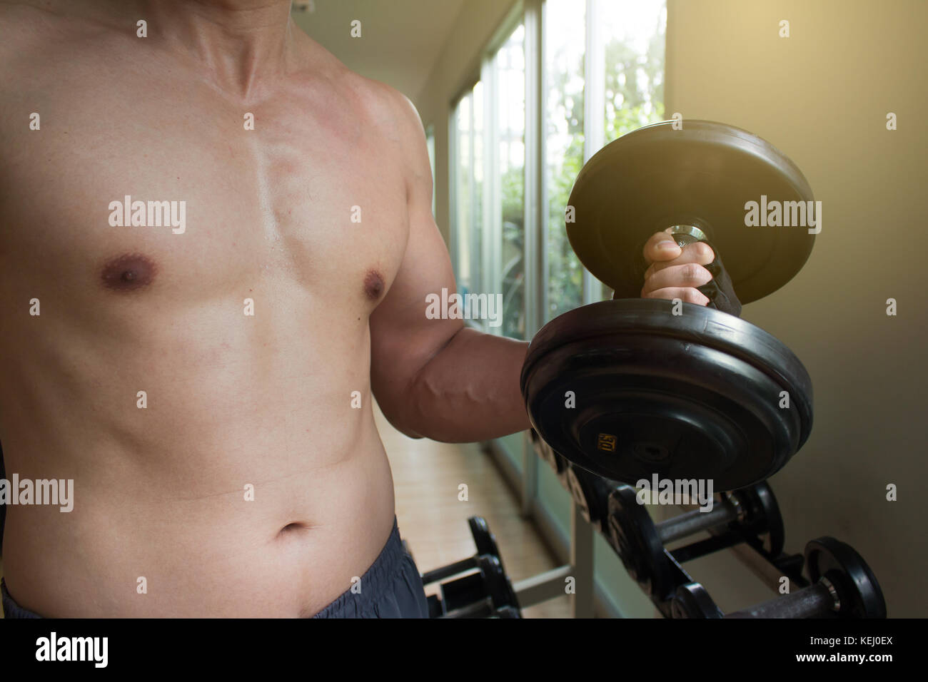 Closeup of a muscular young man lifting weights,a man lifting dumbbell ...