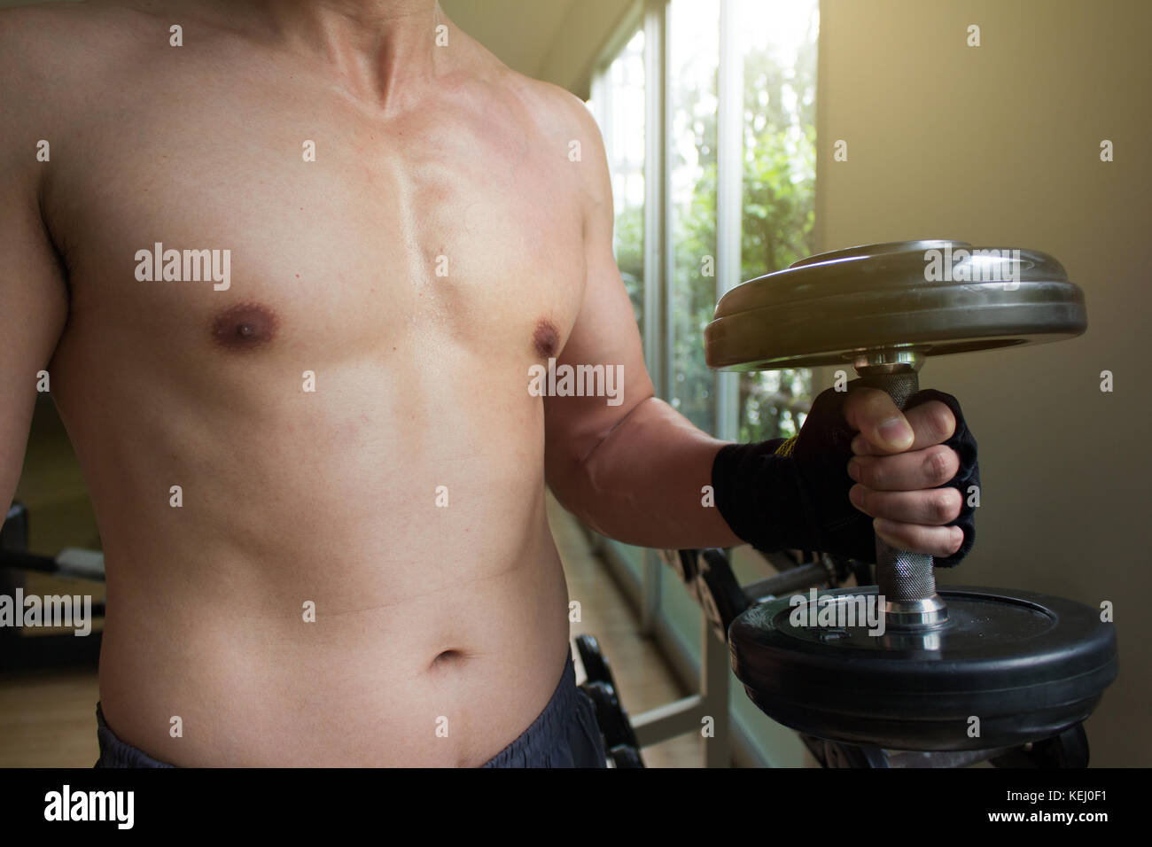 Closeup of a muscular young man lifting weights,a man lifting dumbbell ...