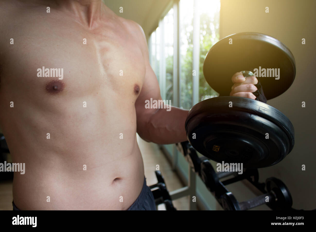 Closeup of a muscular young man lifting weights,a man lifting dumbbell ...