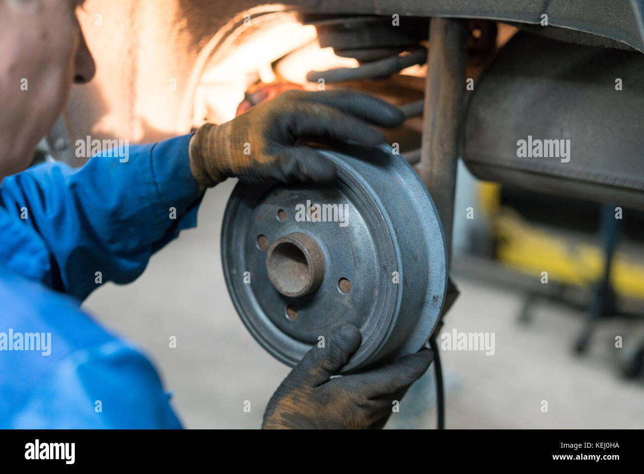 car mechanic worker replacing brakes of lifted automobile at auto ...