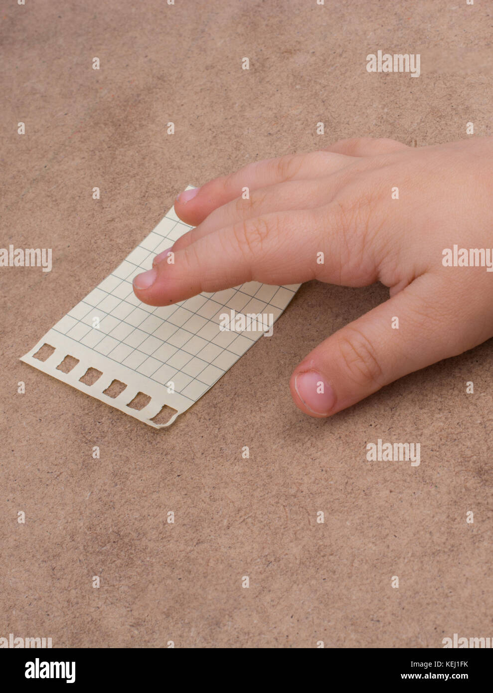 Hand holding a note paper on a brown background Stock Photo - Alamy
