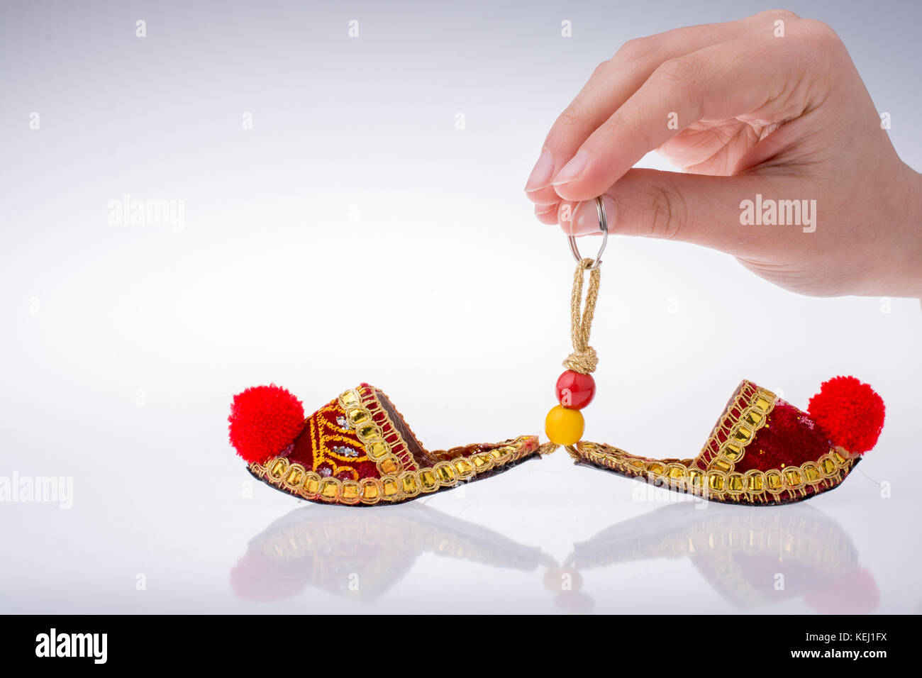 Hand holding traditional Turkish handmade shoes on white background ...