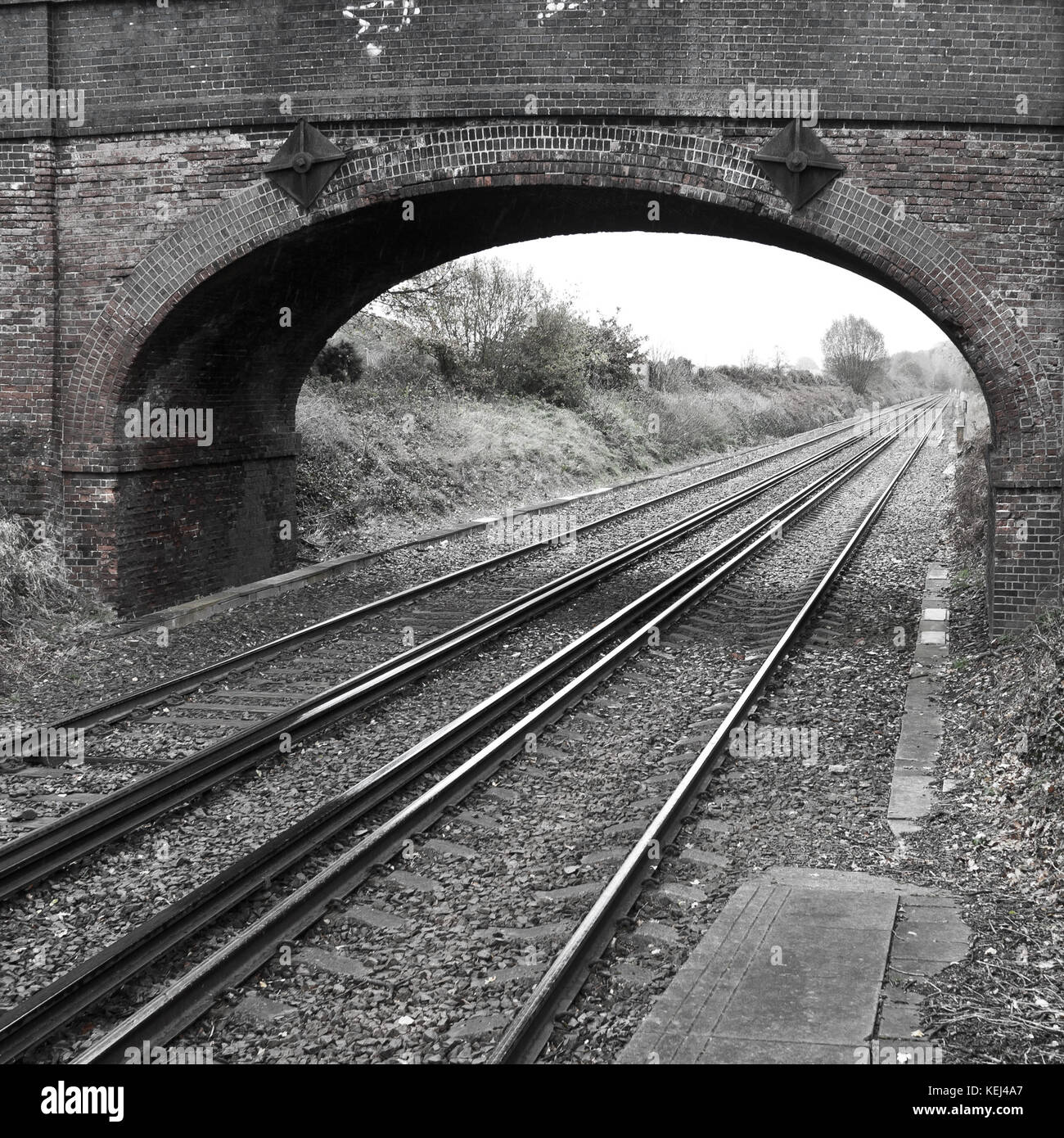 Following the railway tracks underneath a bridge Stock Photo - Alamy
