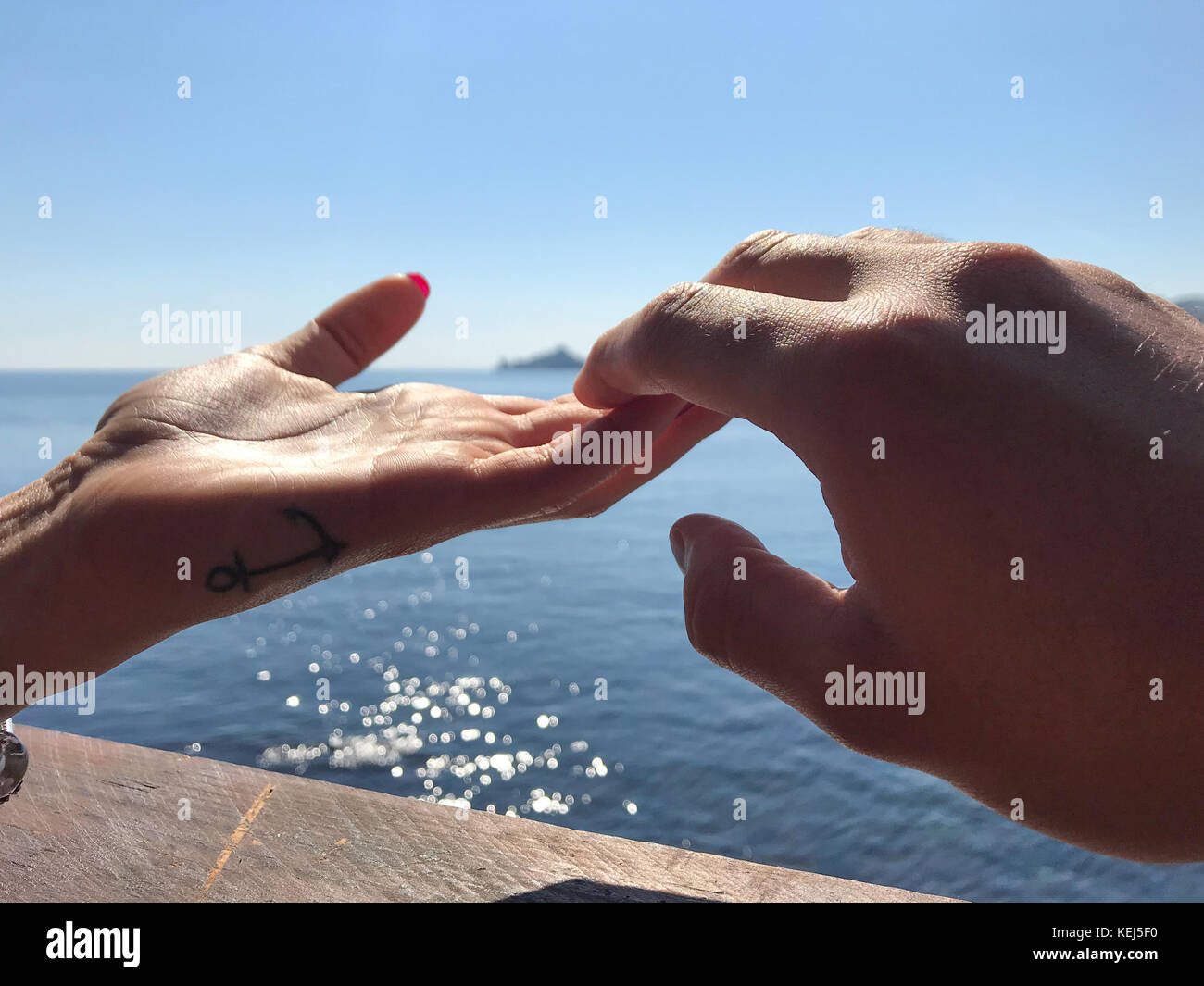 Close-up Couple hands in a sea background Stock Photo - Alamy