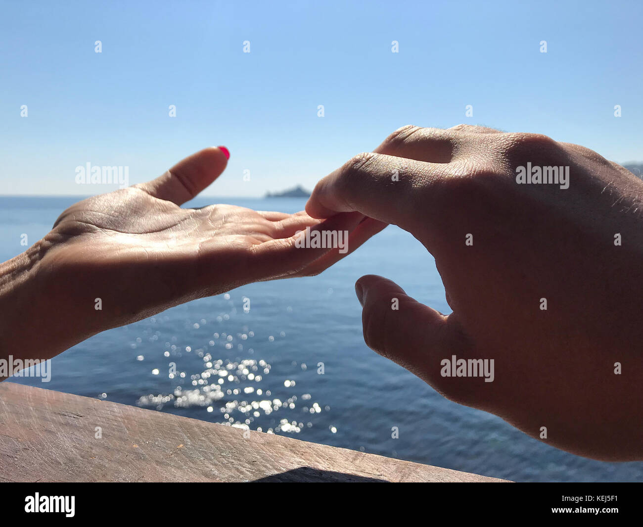 Close-up Couple hands in a sea background Stock Photo - Alamy