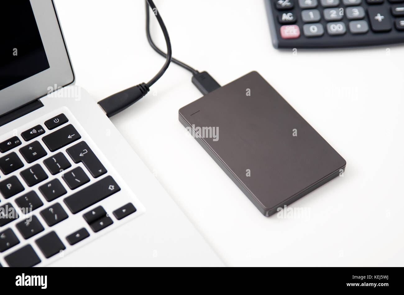 External backup disk hard drive connected to laptop. hard drive backup ...