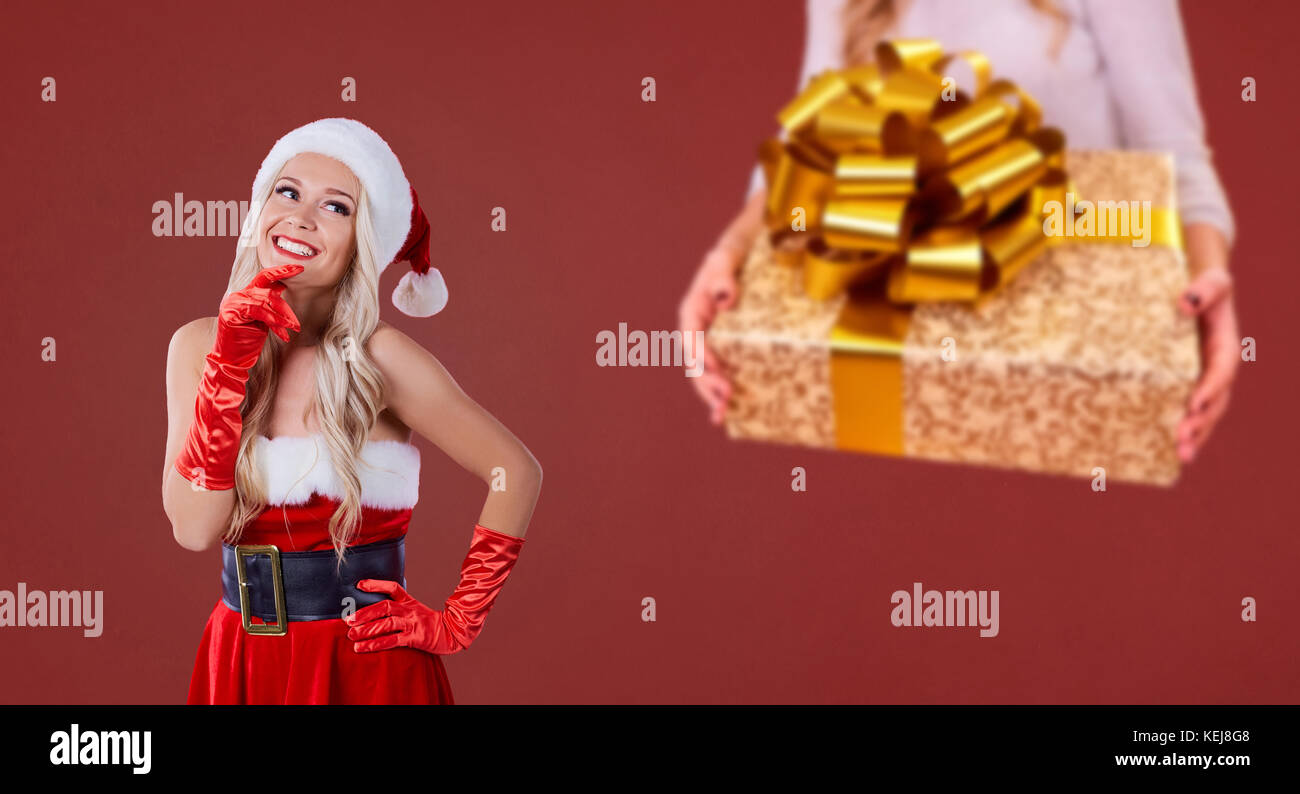 A girl in Santa's costume is dreaming of a gift for Christmas Stock ...