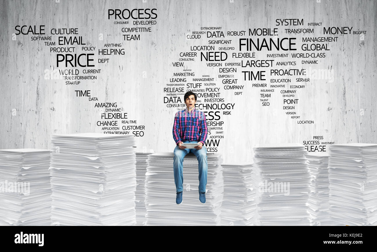 Attractive man sitting on pile of paper documents Stock Photo - Alamy