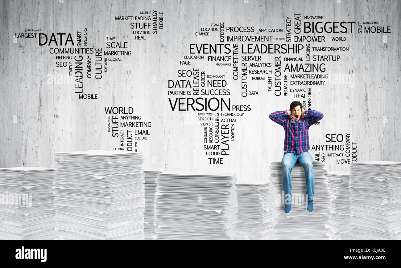 Attractive man sitting on pile of paper documents Stock Photo - Alamy