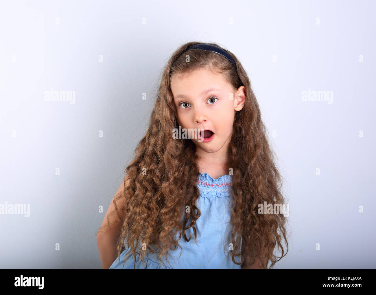 Excited surprising kid girl with wide open mouth and big eyes looking ...