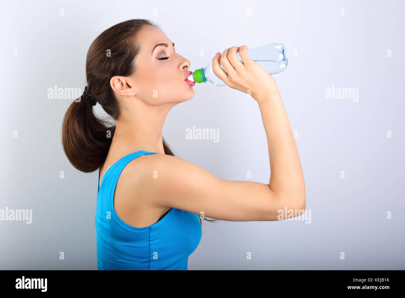 Beautiful Happy Sporty Slim Woman Holding And Drinking Water From The