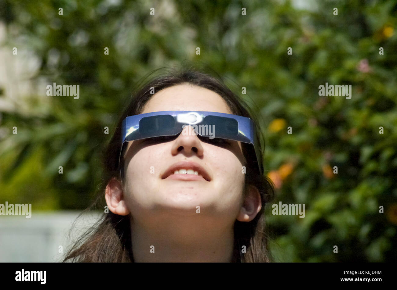 a young student, looking at the sun with special glasses, during a ...