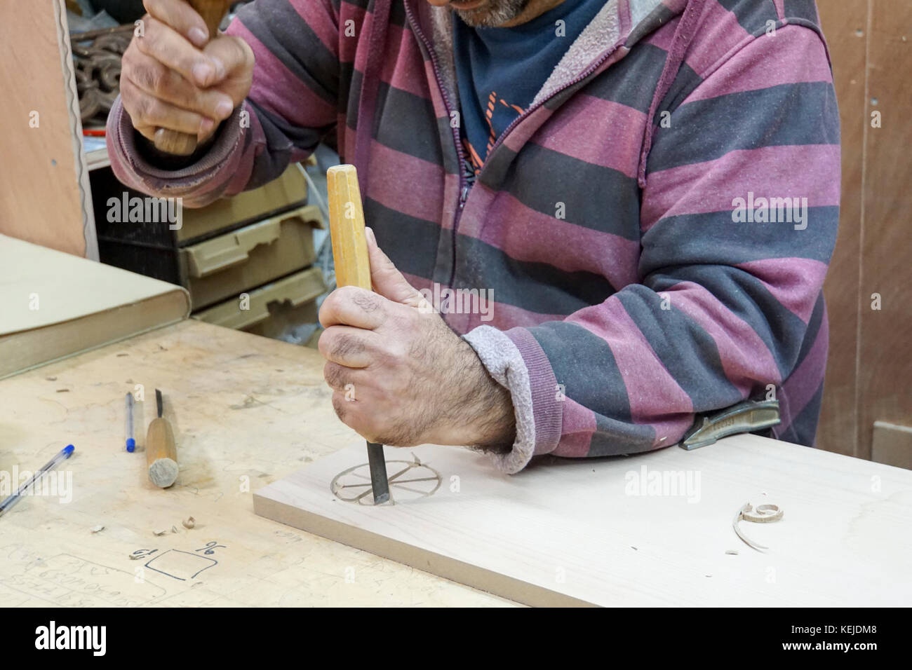 A man engraving a block of wood with a mallet and chisel Stock Photo ...