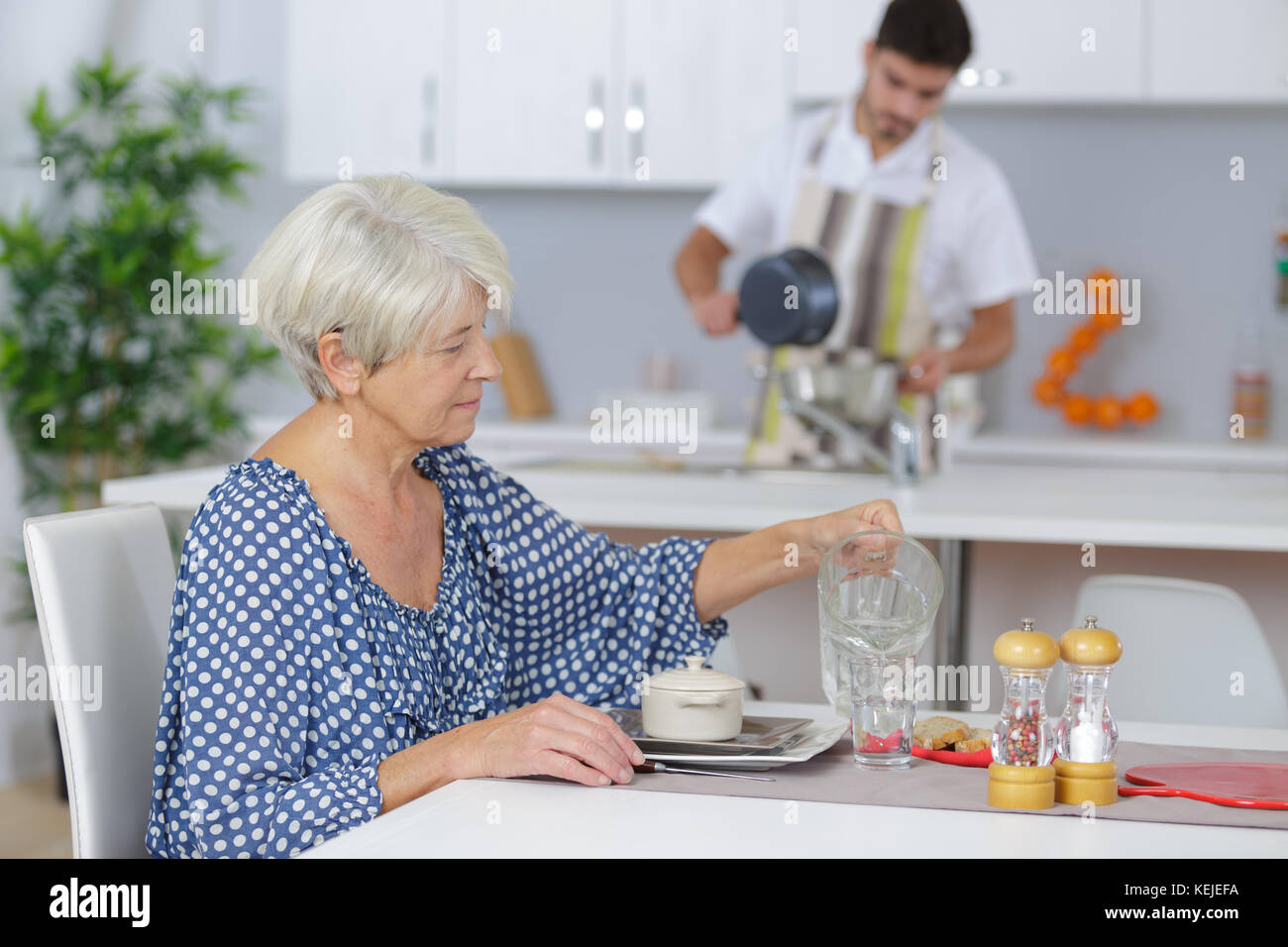 cheerful young man serving breakfast to an elderly woman Stock Photo ...