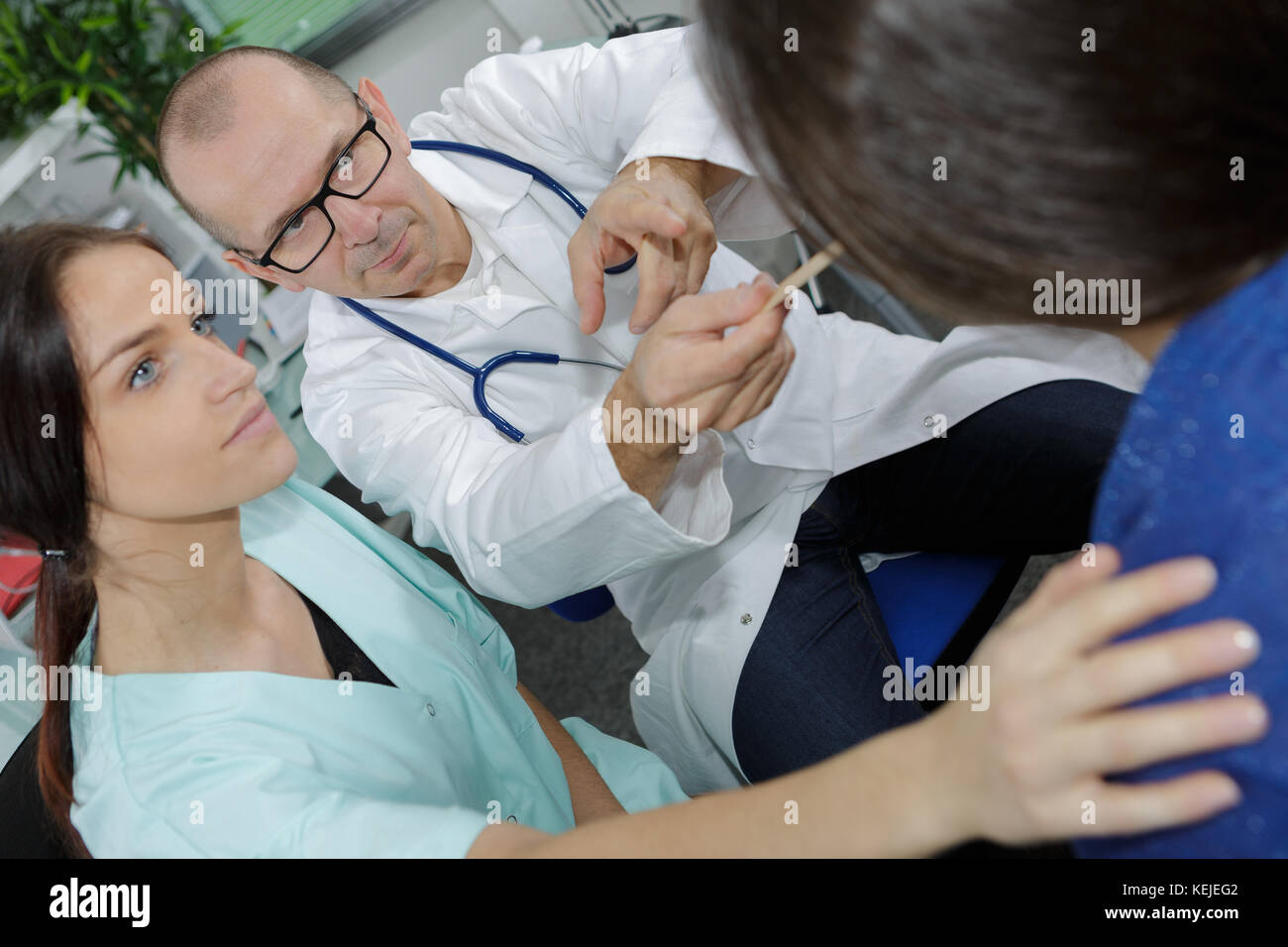 doctor and nurse inspecting patient Stock Photo - Alamy