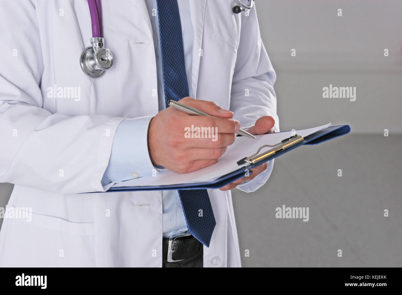 Male doctor standing with folder, isolated on white background Stock ...