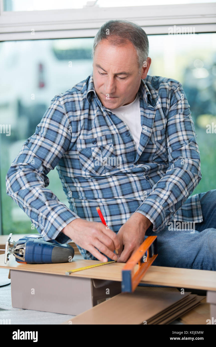 craftsman measuring a plank of wood with a spirit level Stock Photo - Alamy