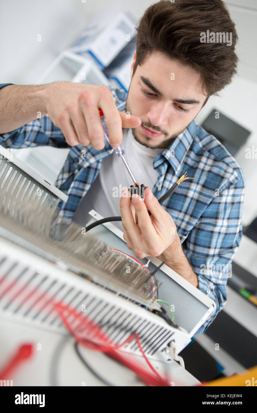 young handsome man repairing radiator Stock Photo - Alamy
