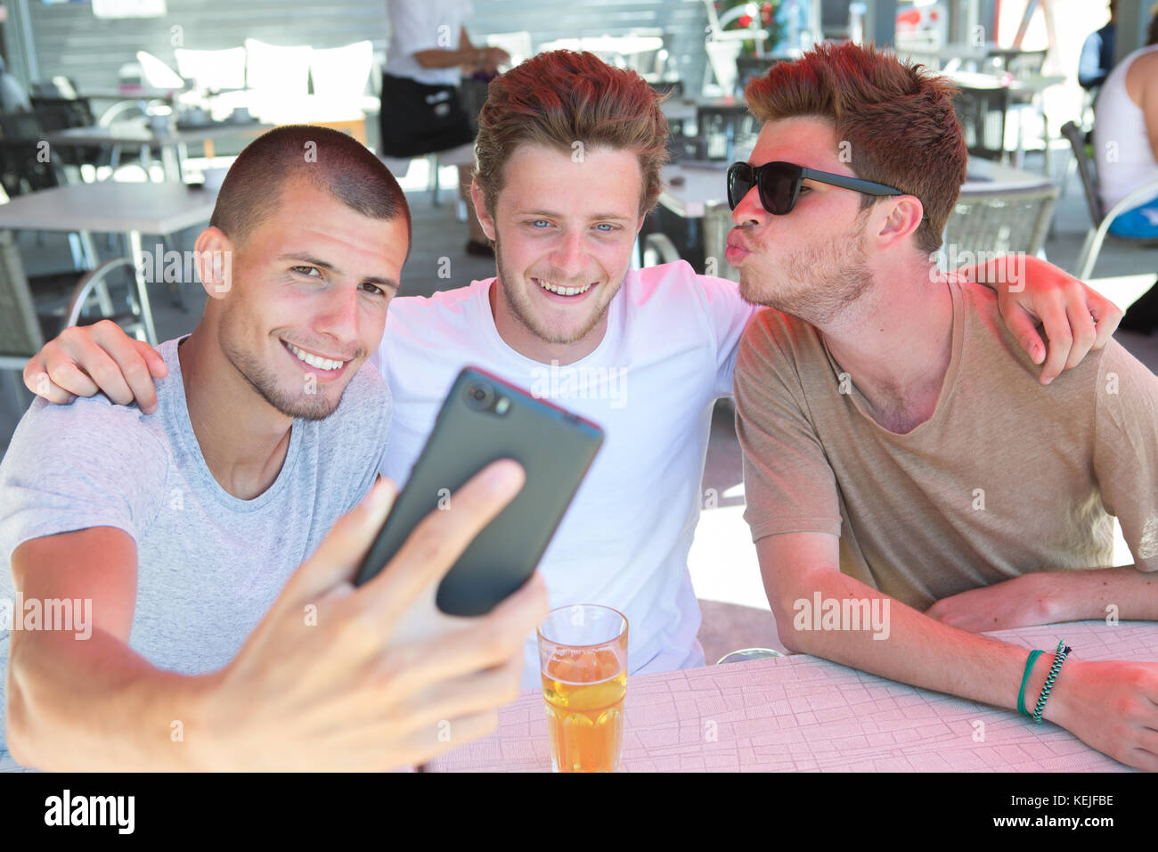 Three young men taking selfie with smartphone Stock Photo - Alamy