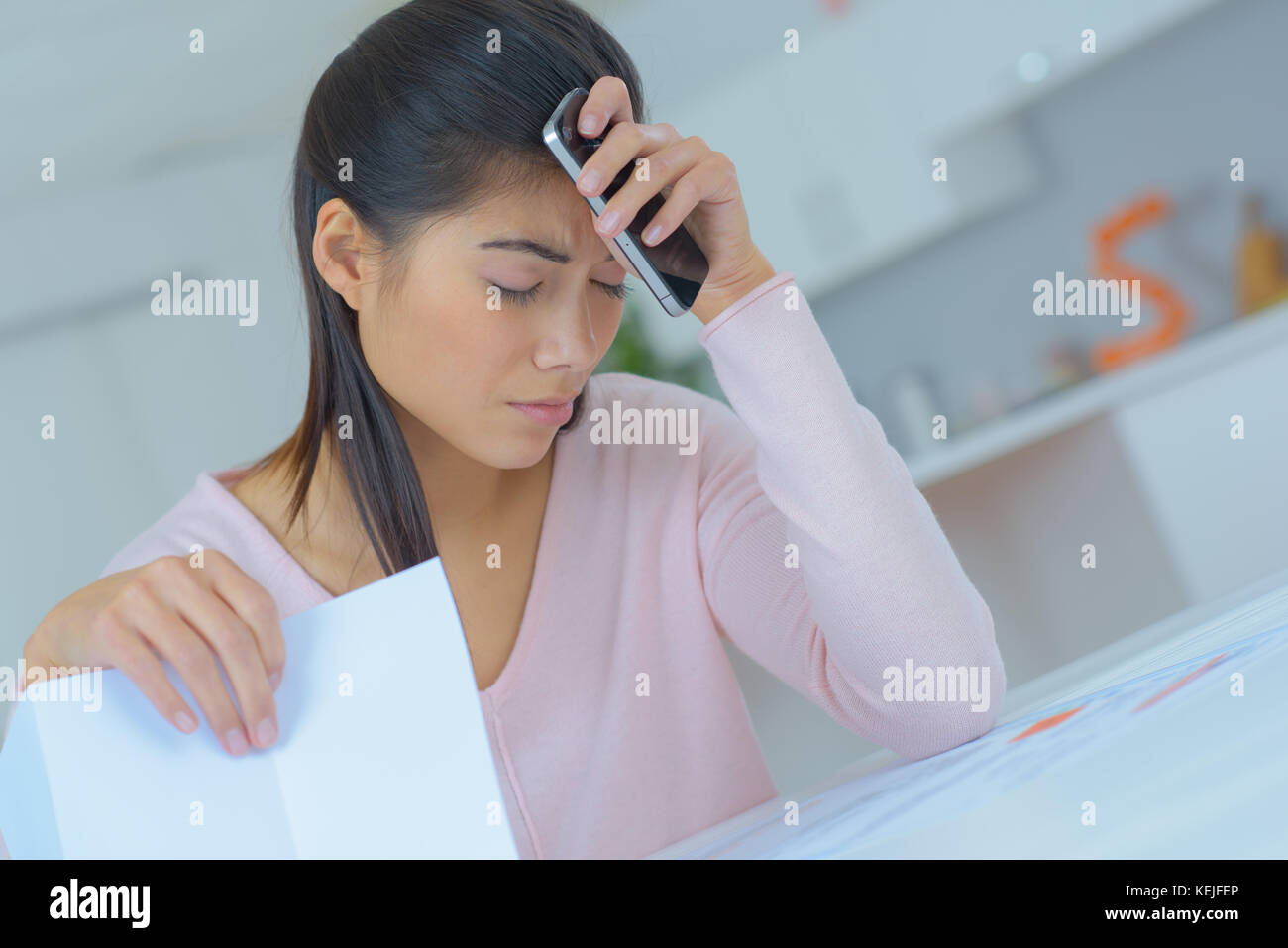 Worried lady doing paperwork Stock Photo - Alamy