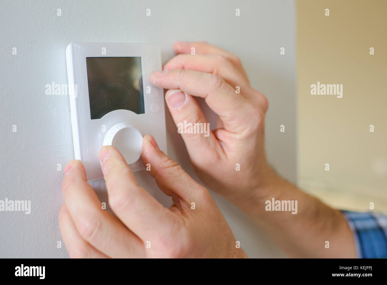 hand pressing button on digital thermostat Stock Photo - Alamy