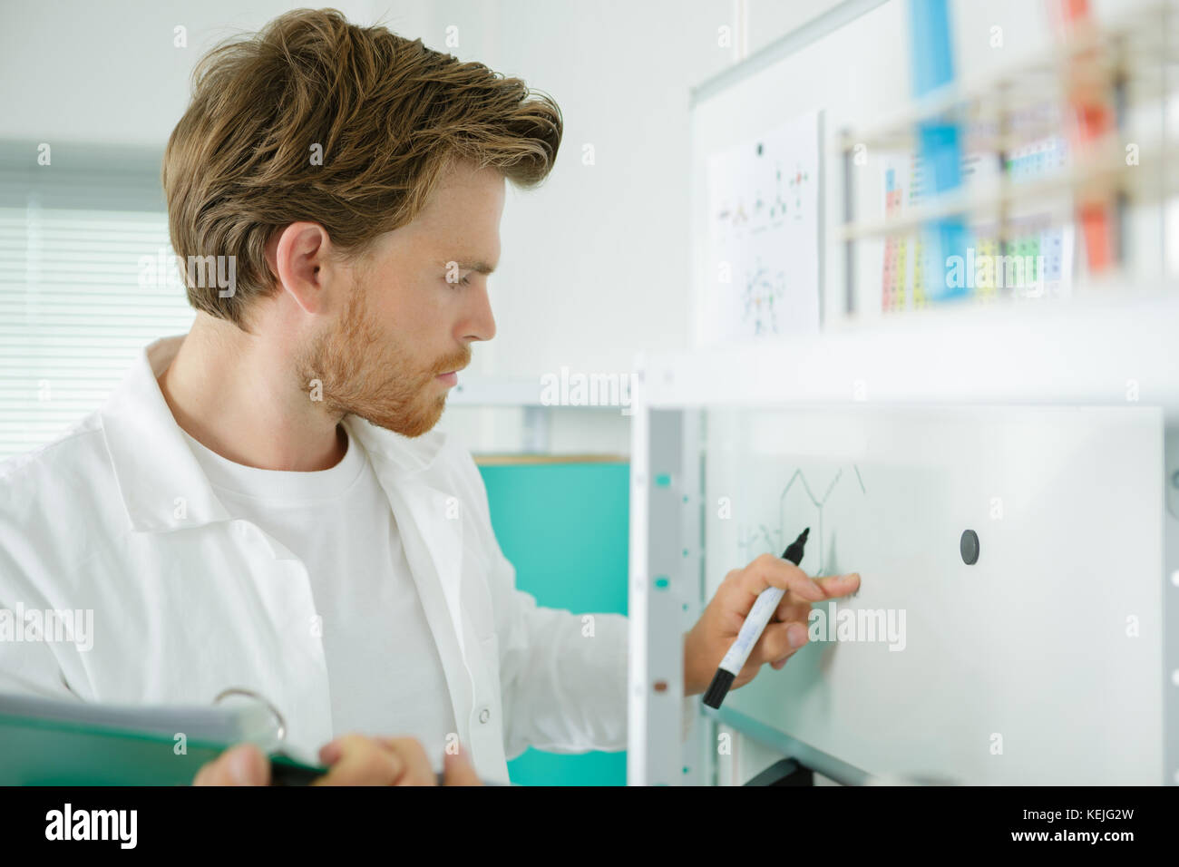 Man charting graph on whiteboard Stock Photo - Alamy