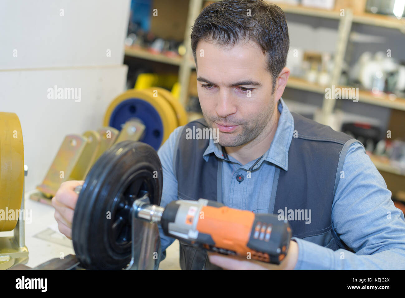 man reairing trolley wheel in workshop Stock Photo - Alamy