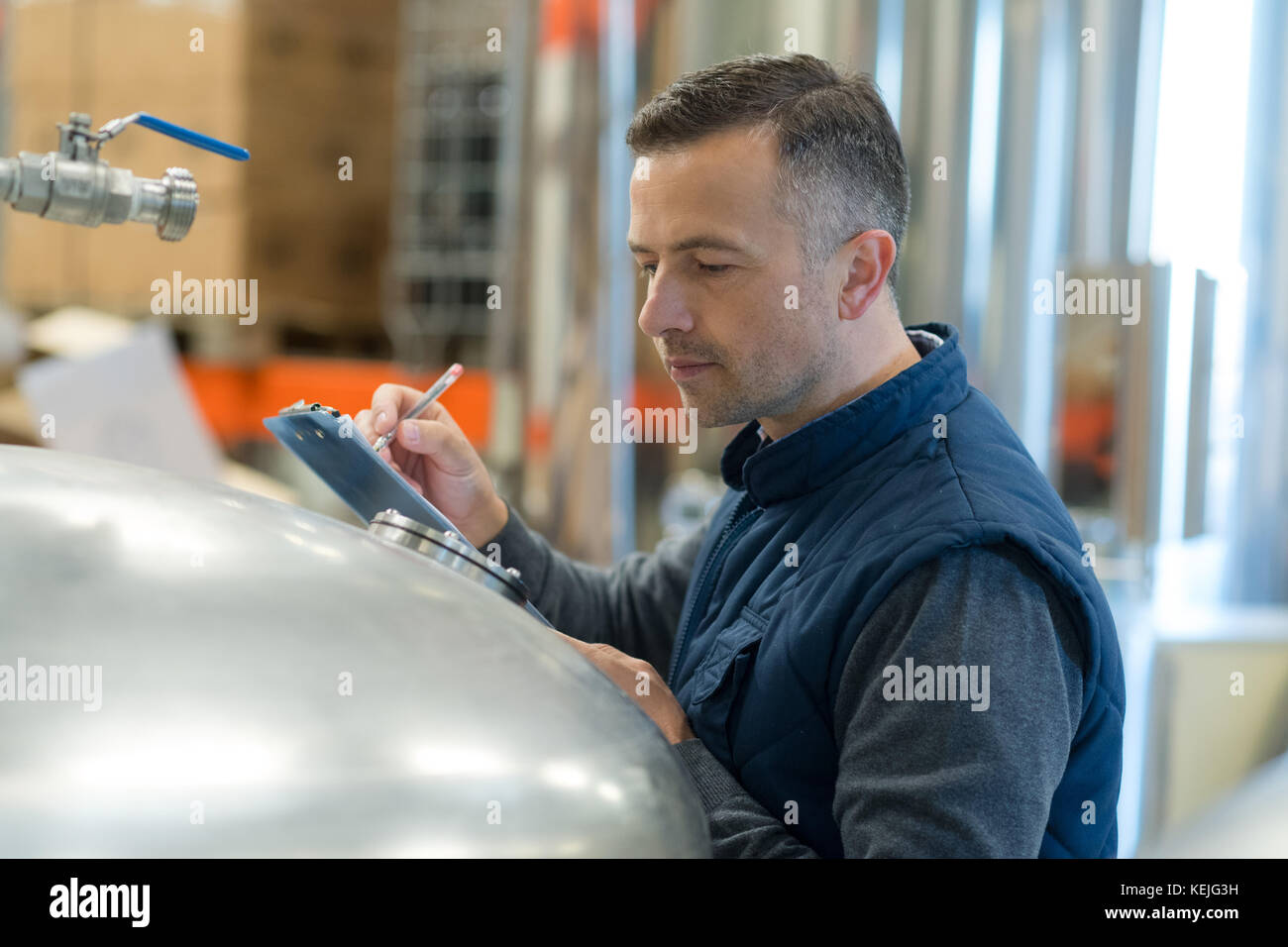 male supervisor holding clipboard in metal industry Stock Photo - Alamy
