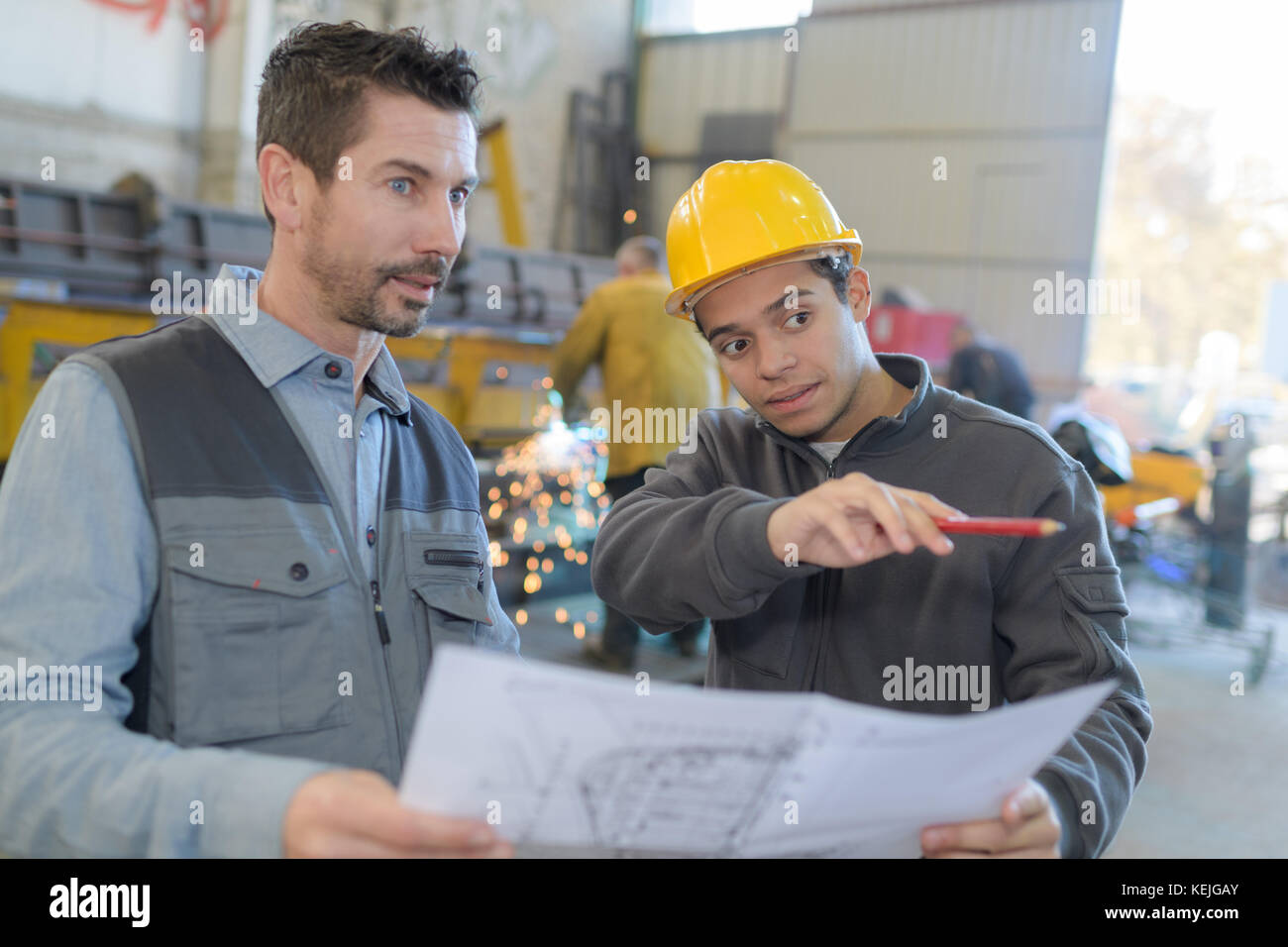 industrial manager and worker showing machine Stock Photo - Alamy
