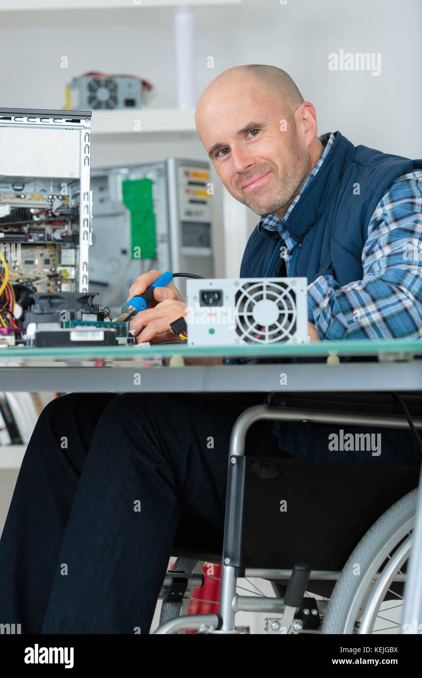 male worker sitting at desk in wheelchair Stock Photo - Alamy