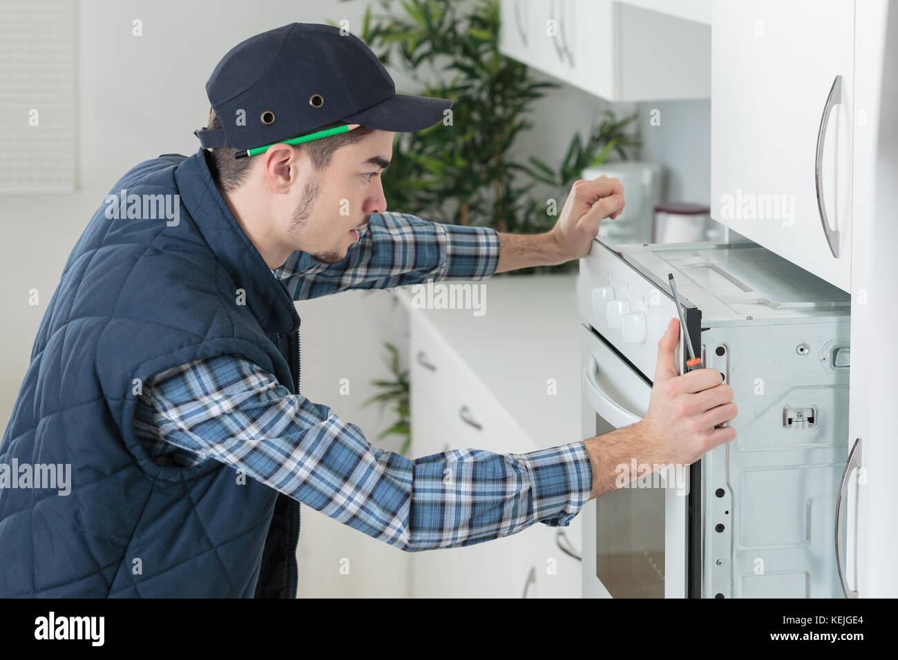 Man fitting new oven Stock Photo - Alamy