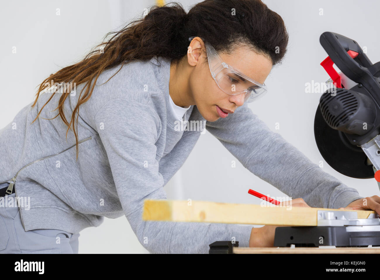 female carpenter measuring and marking wood Stock Photo - Alamy