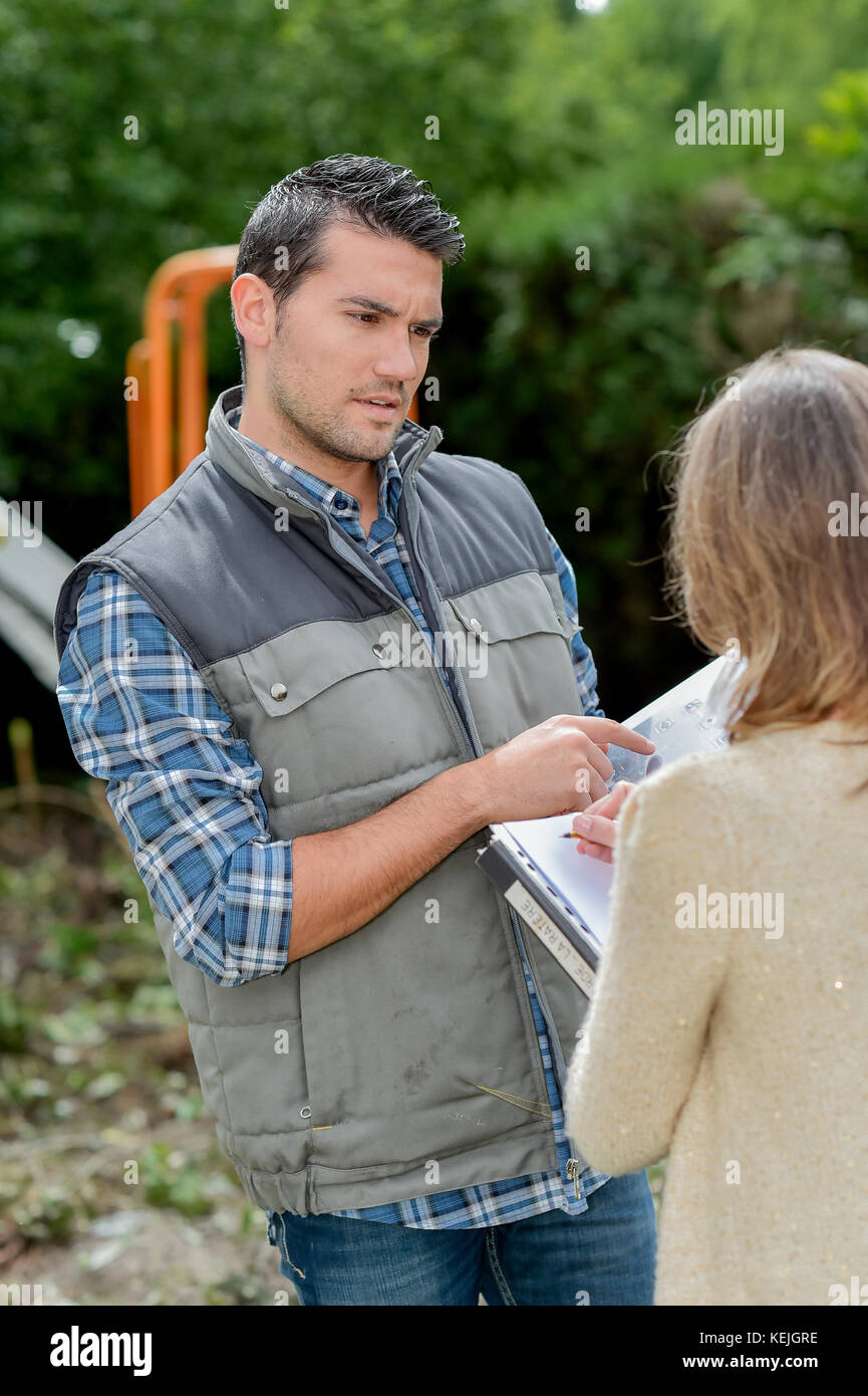Foreman chatting to client at the building site Stock Photo - Alamy