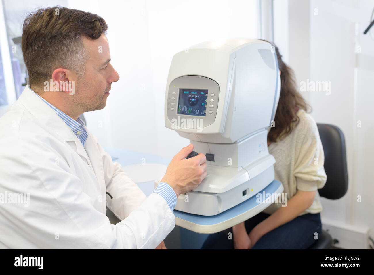 woman looking at eye test machine in ophthalmology clinic Stock Photo ...