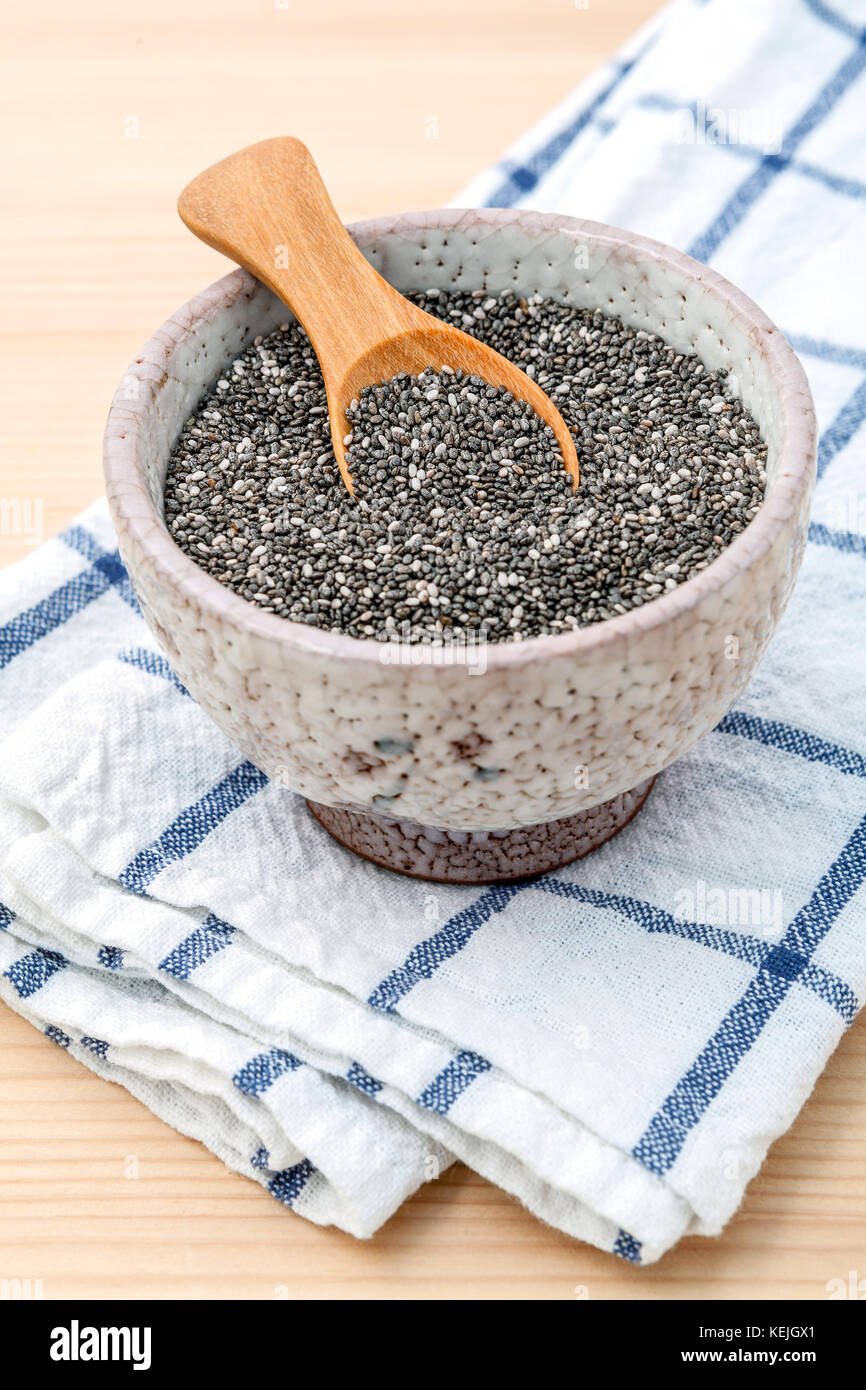 Nutritious chia seeds in ceramic bowl with wooden spoon for diet food ...