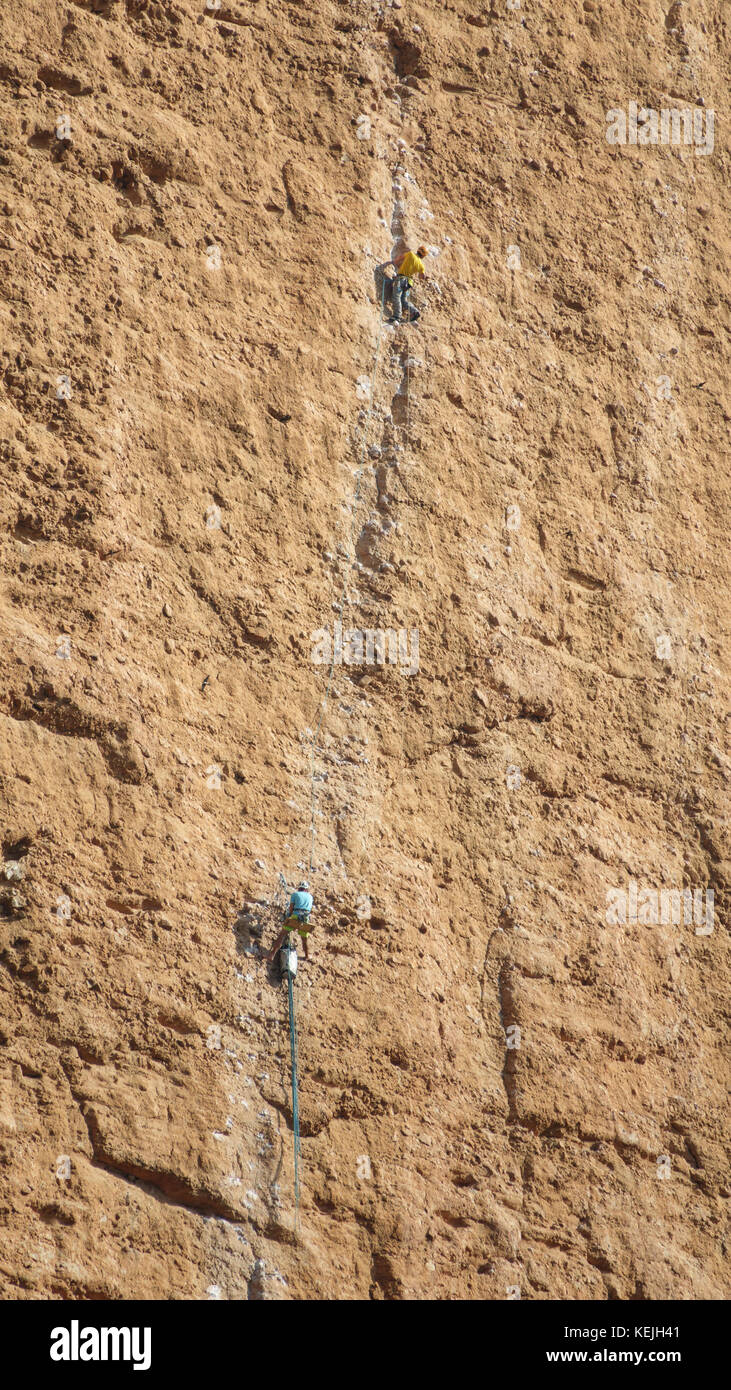 Male climbers hanging by a cliff in a row Stock Photo - Alamy