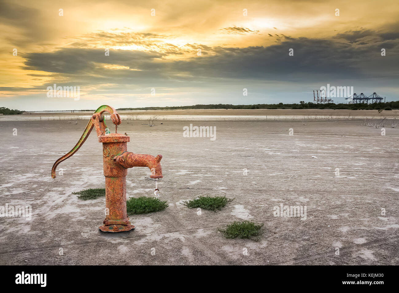 Rusty water pump on barren ground sunset Stock Photo - Alamy