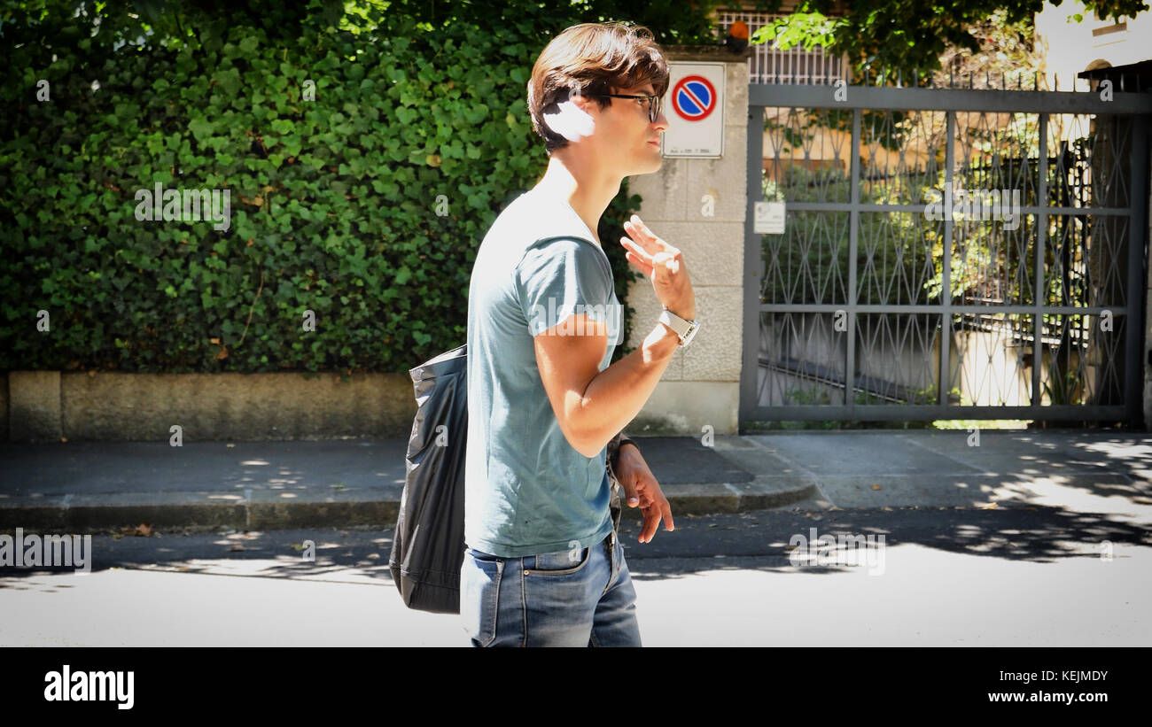Young handsome man tossing junk on the ground in a park while walking ...