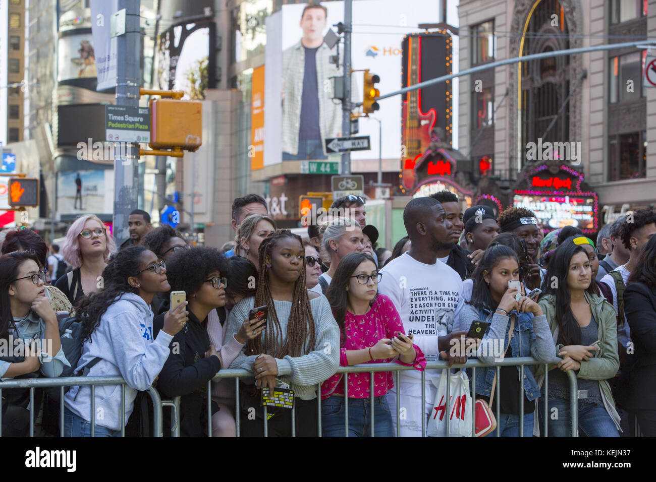 Young people & tourists stand behind barricades in Times Square to get ...