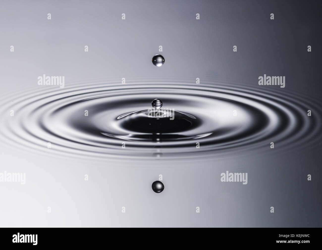 A macro shot of two water drops falling into a pool of water Stock ...