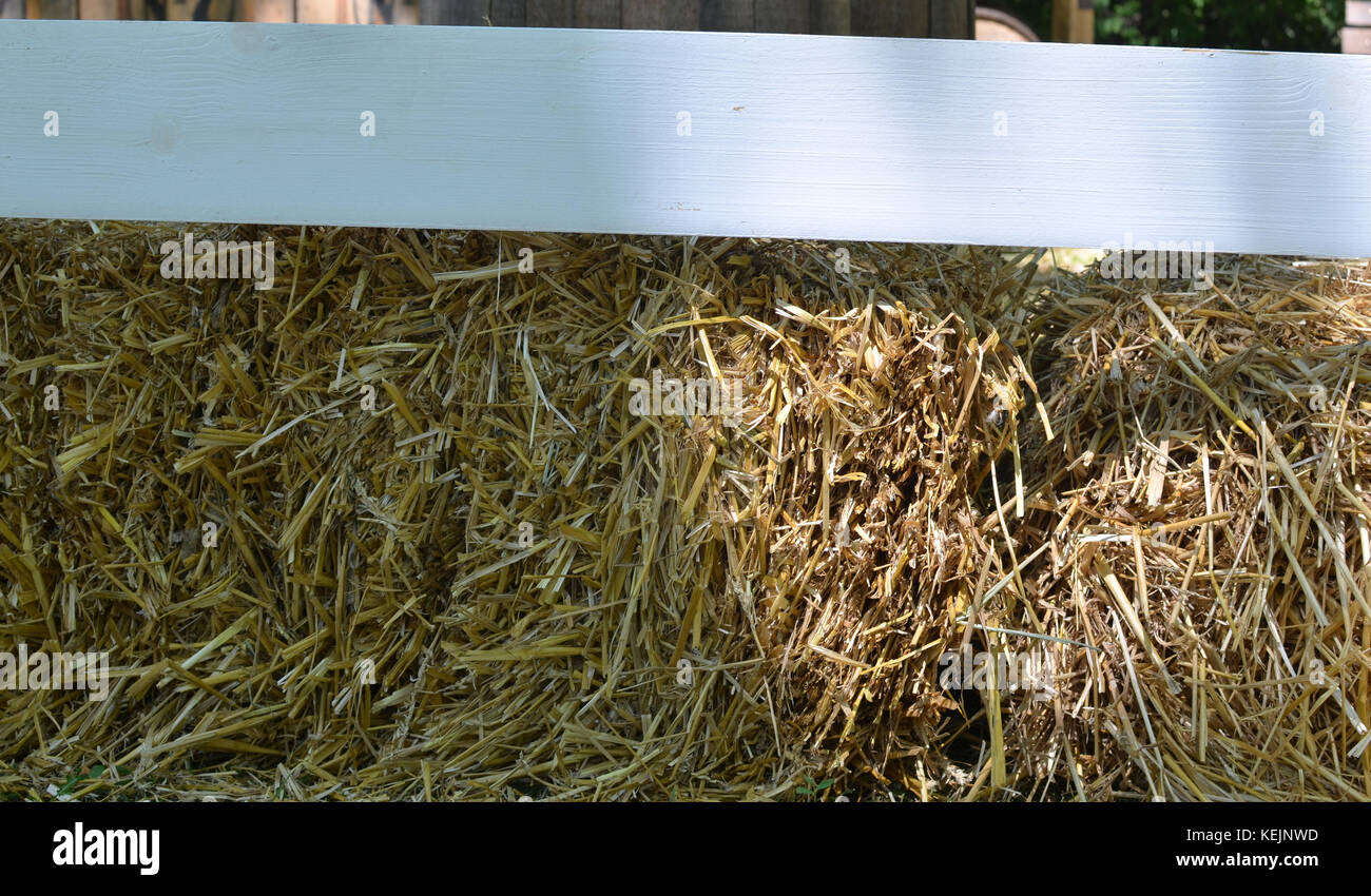 Hay bale behind white wooden barn fence Stock Photo - Alamy